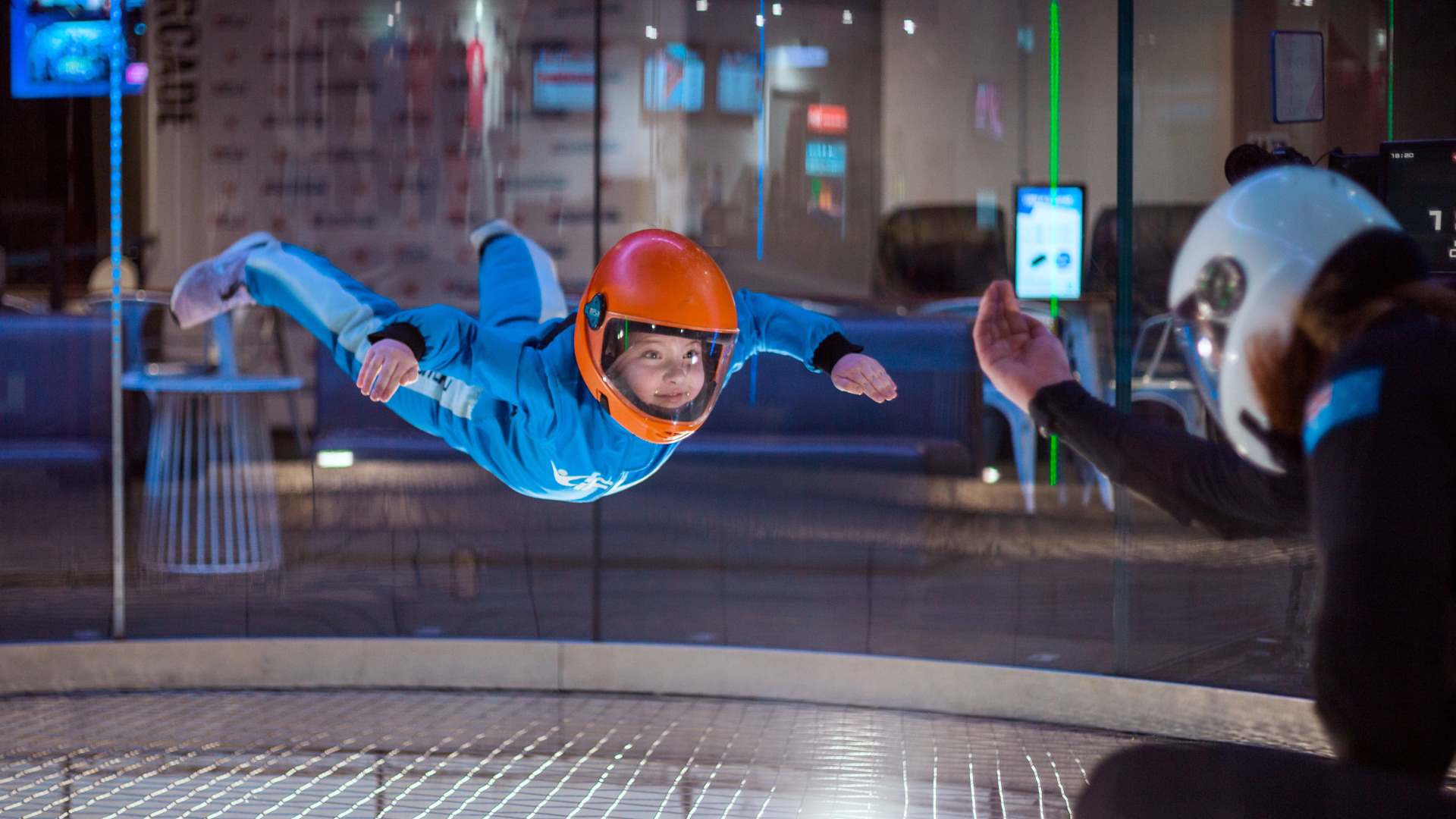 Child flying in a blue jump suit with Instructor present.